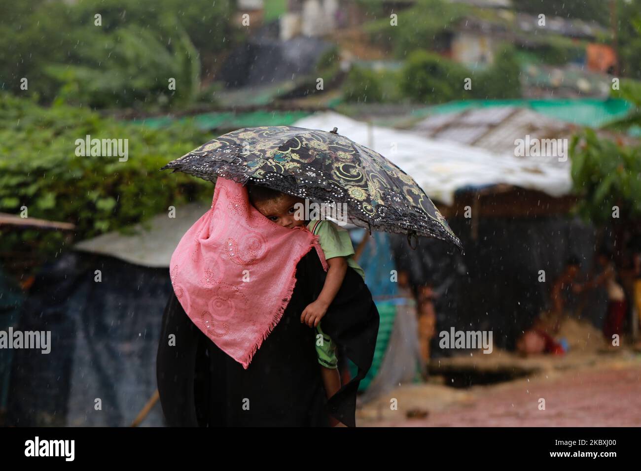 Rohingya refugees walk during a monsoon rain at Kutupalong refugee camp ...