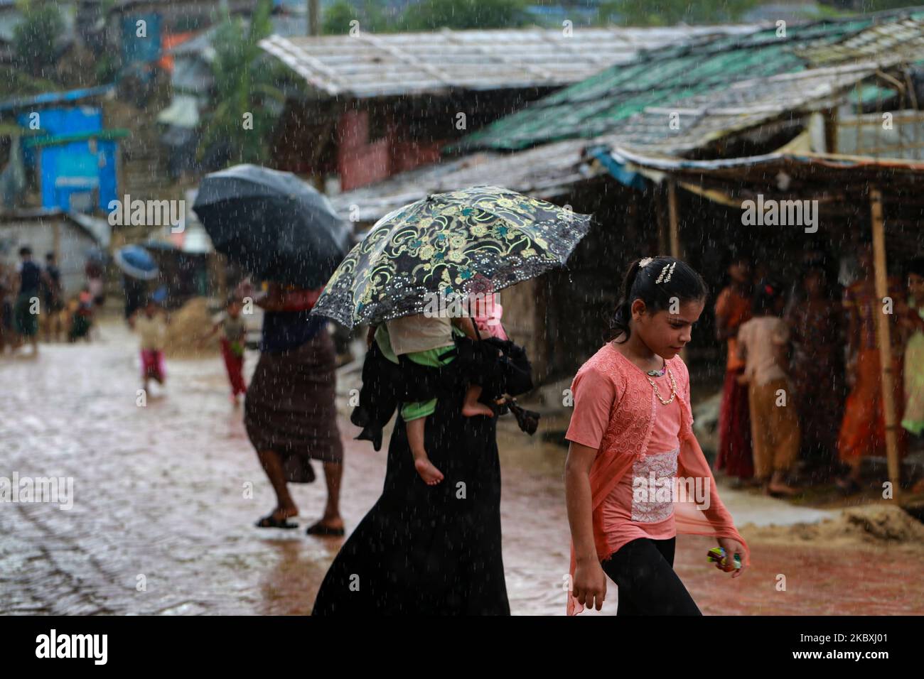 Rohingya refugees walk during a monsoon rain at Kutupalong refugee camp ...