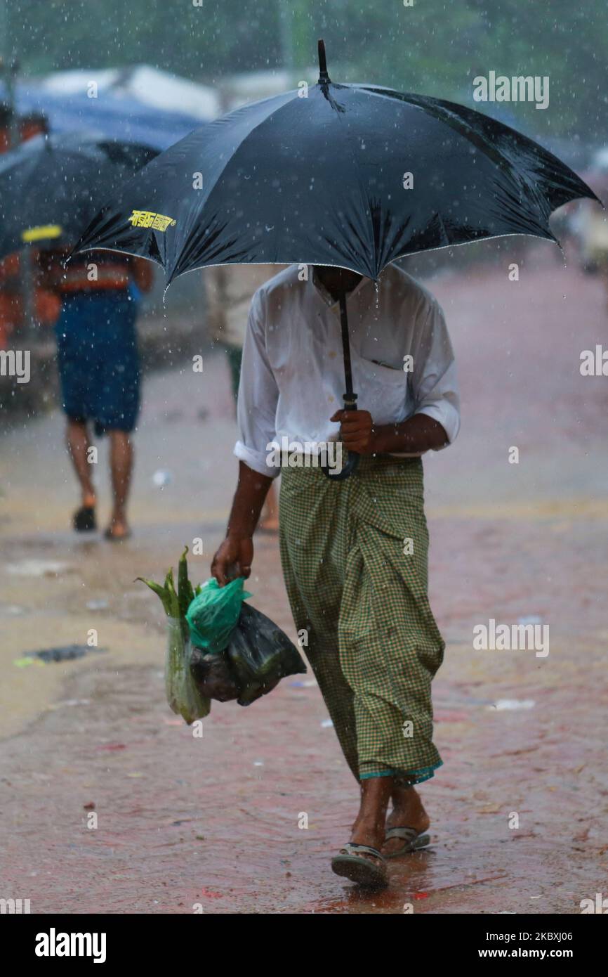 Rohingya refugees walk during a monsoon rain at Kutupalong refugee camp ...