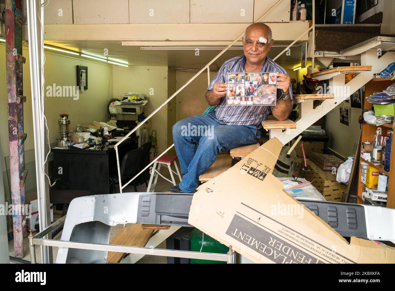 A Lebanese man sitting in his damaged shop in Beirut holding in his ...