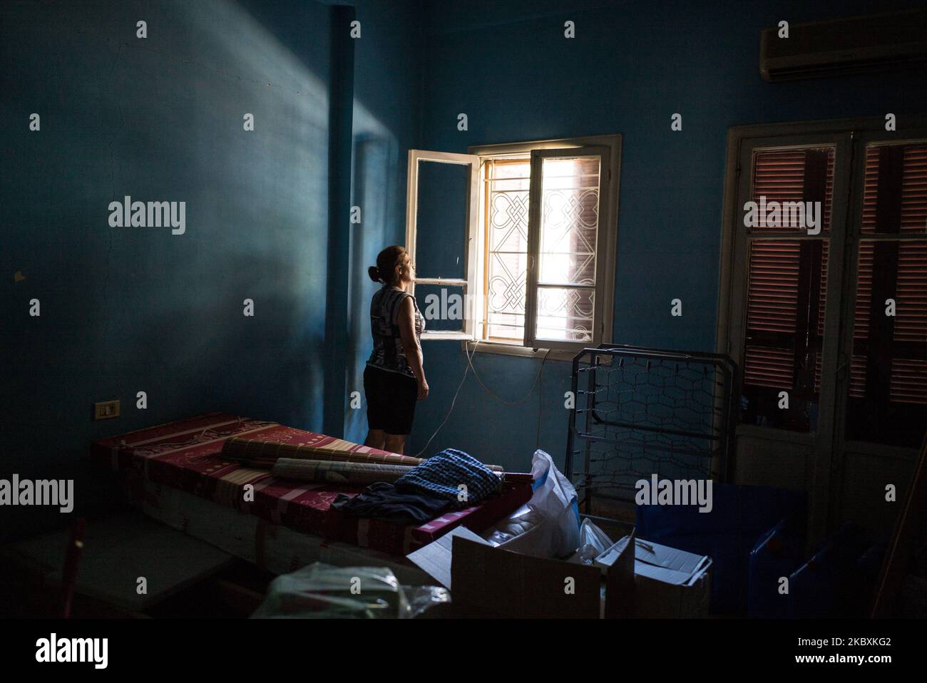 A woman is looking outside the window of her house in Mdawar area on ...
