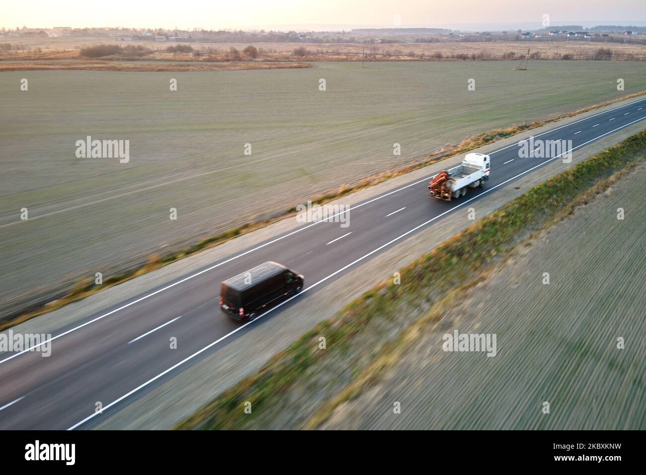 Aerial view of intercity road with fast driving cars at sunset. Top ...