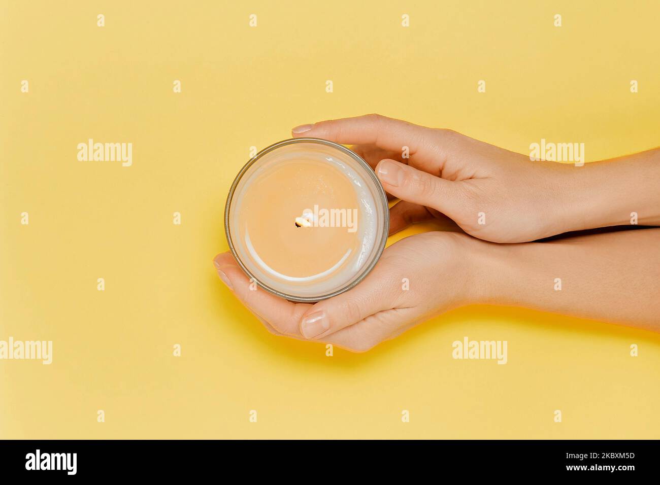 Female hands with scented candle and flowers. Aromatherapy and spa ...