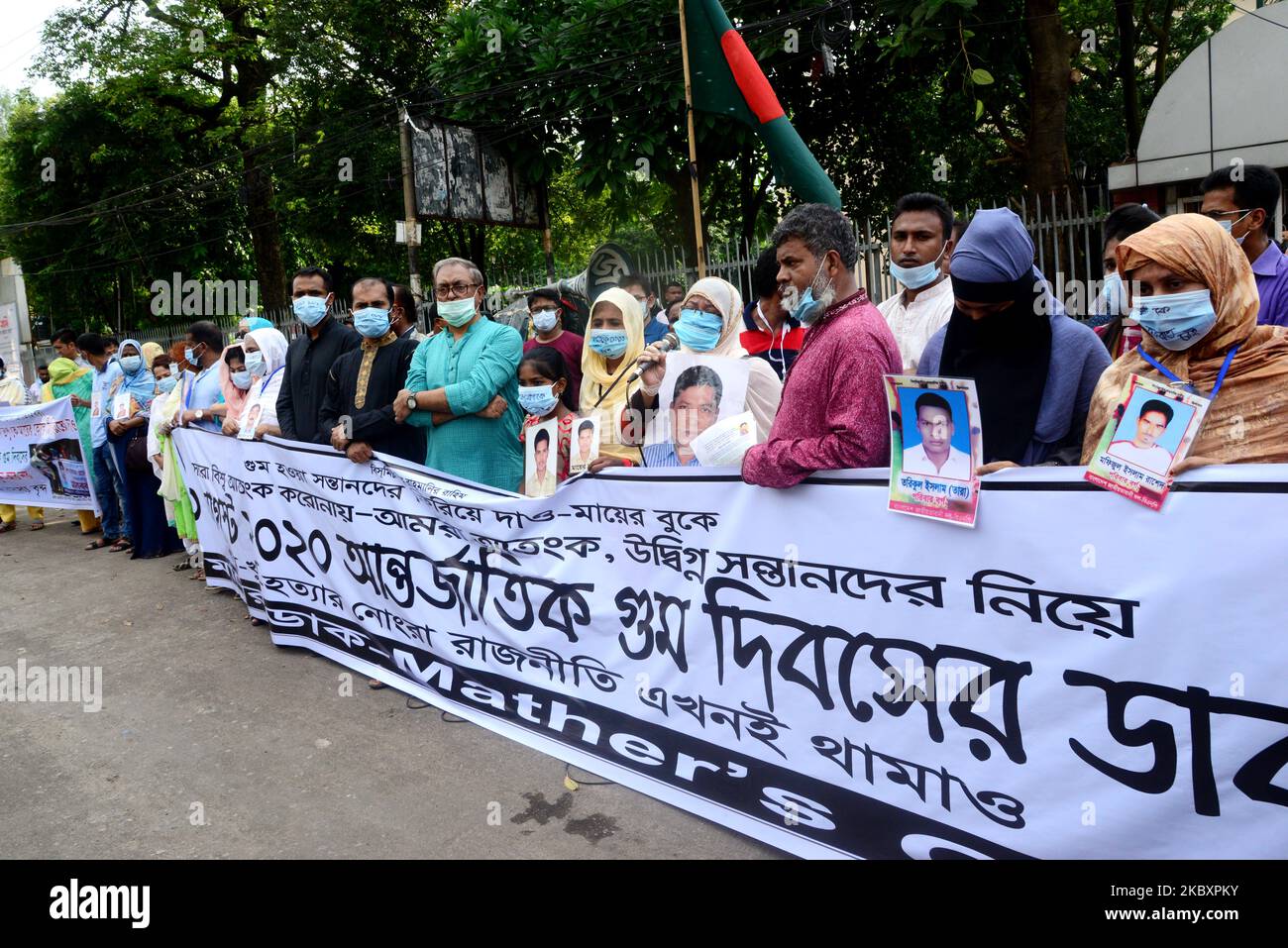 Relatives hold portraits of their missing family members as they form human chain ahead of the ...