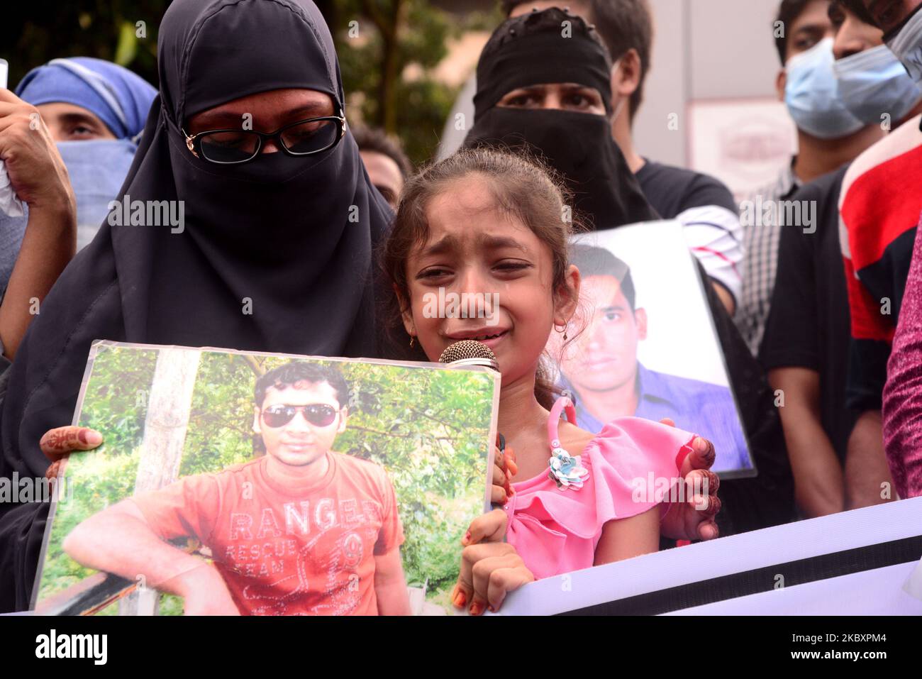 Relatives hold portraits of their missing family members as they form ...