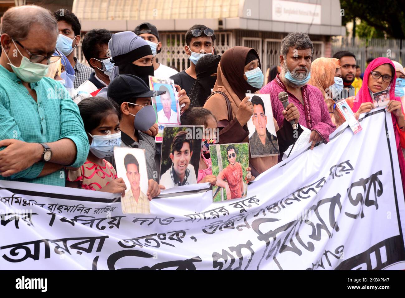 Relatives hold portraits of their missing family members as they form human chain ahead of the ...