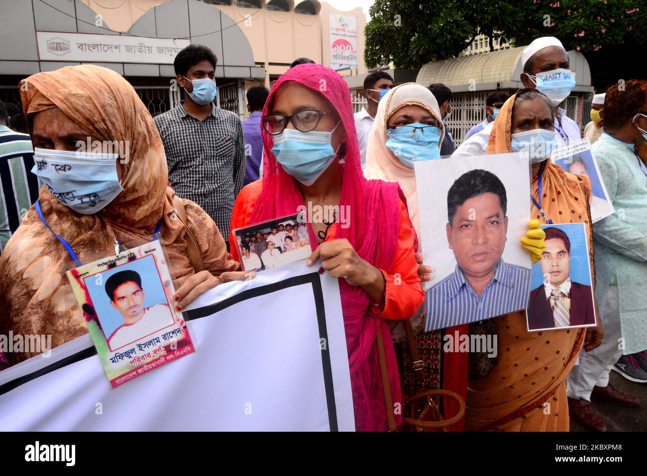 Relatives hold portraits of their missing family members as they form ...