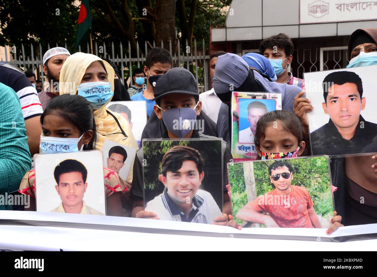 Relatives hold portraits of their missing family members as they form ...