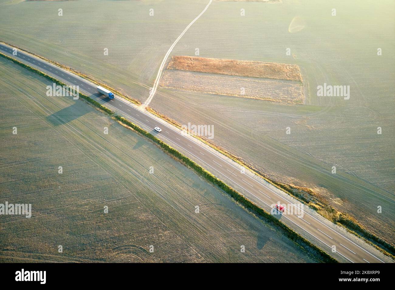 Aerial view of intercity road with fast driving cars at sunset. Top ...