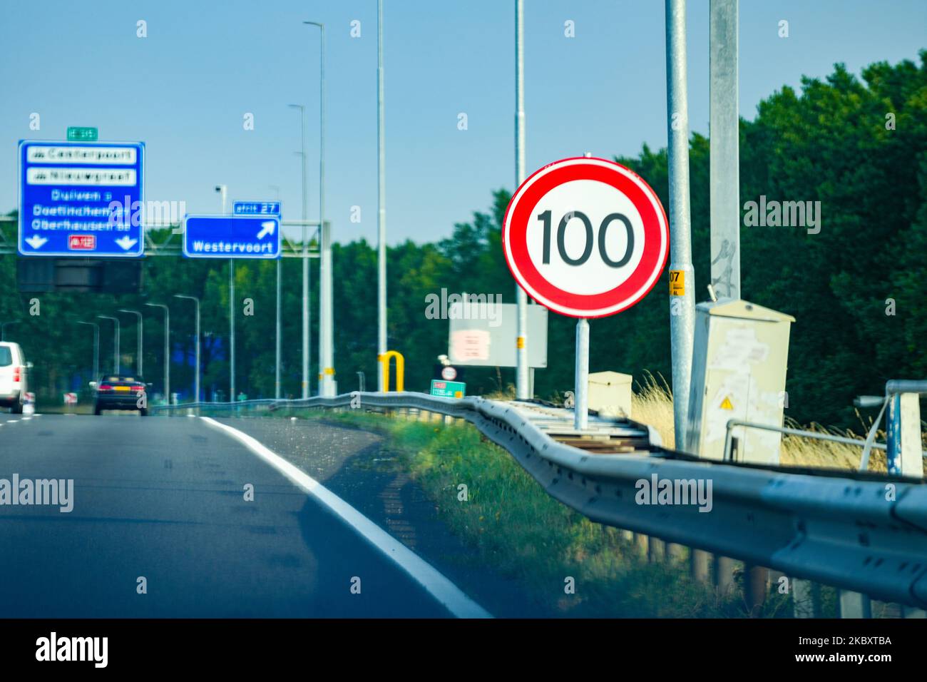 A road sign showing a speed limitation of 100 on a highway Stock Photo ...