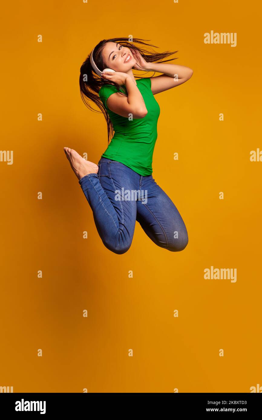 Jumping high, flying. Young woman's portrait on color studio background ...