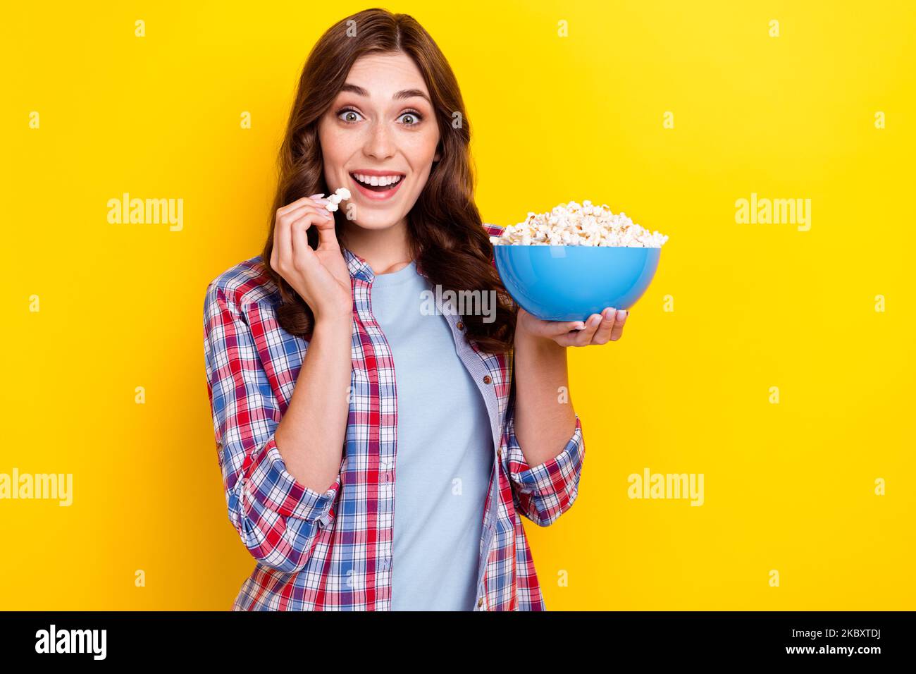 Closeup photo of young excited shocked girl eating popcorn watching ...