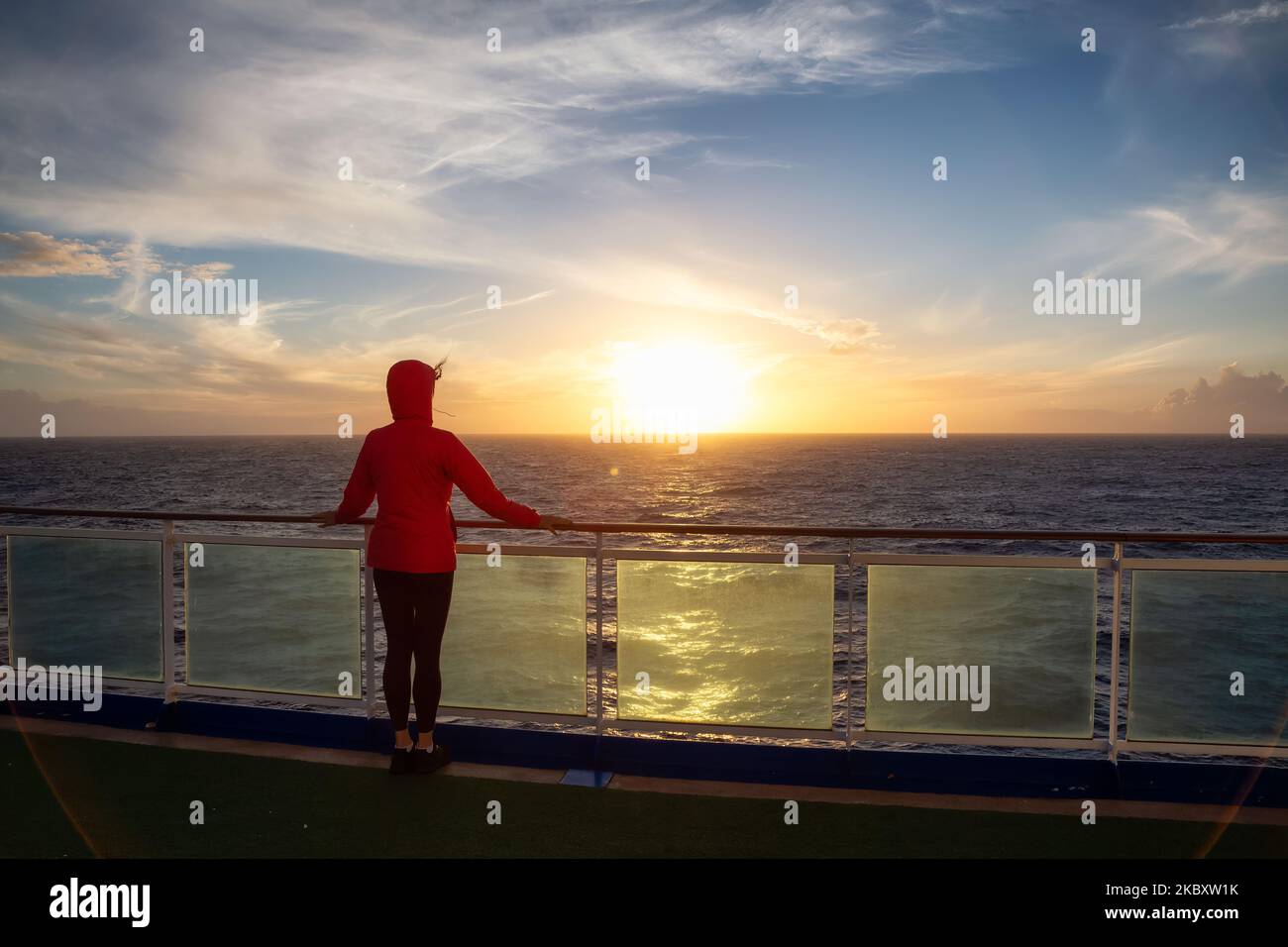 Adventure woman traveler enjoying colorful sunset from a Cruise Ship ...