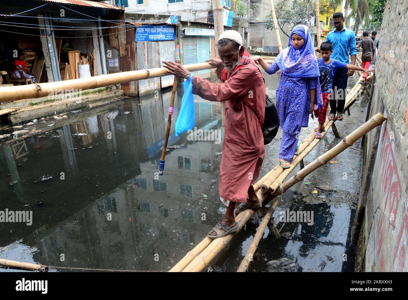 Residents cross bamboo made bridge over a waterlogged street in Dhaka ...