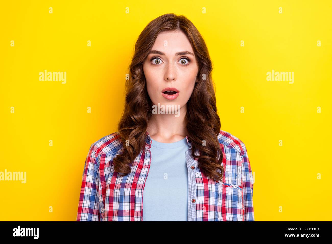 Photo of pretty impressed young girl dressed checkered shirt big eyes ...