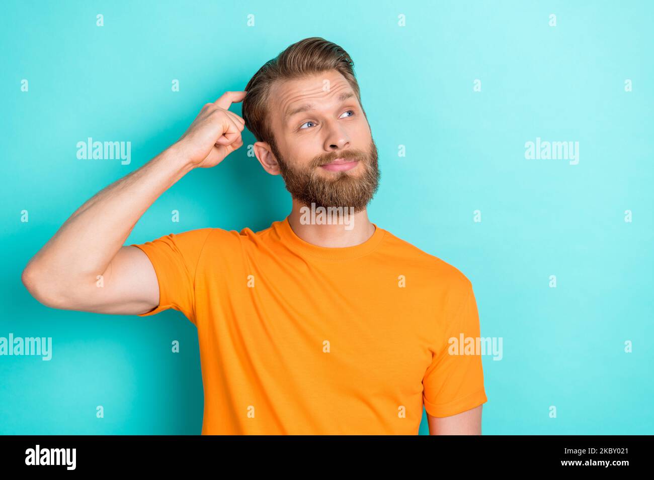 Portrait of positive intelligent guy with blond hairdo wear orange t ...