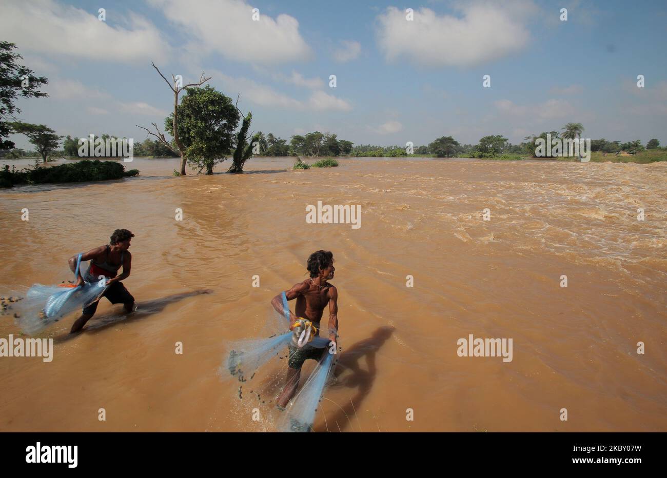 Flood affected villagers are seen near to the broken river embankments ...