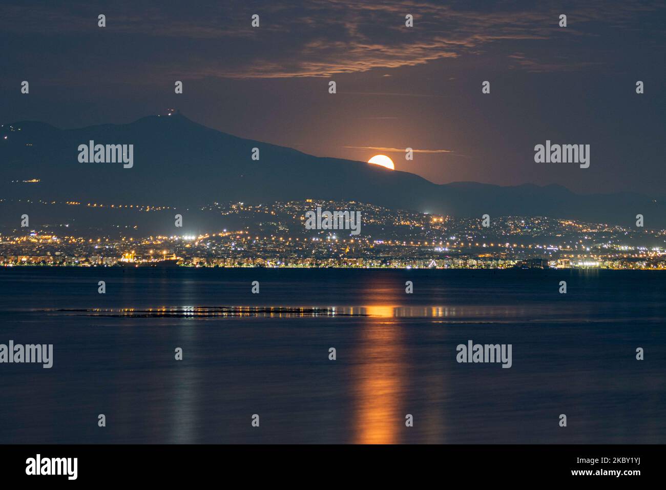 The Full Corn Moon as seen behind Hortiatis mountain over the city of ...