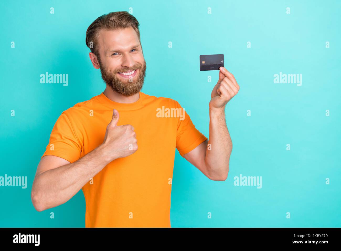 Photo Of Boss Beard Guy Hold Card Thumb Up Wear Orange T Shirt Isolated
