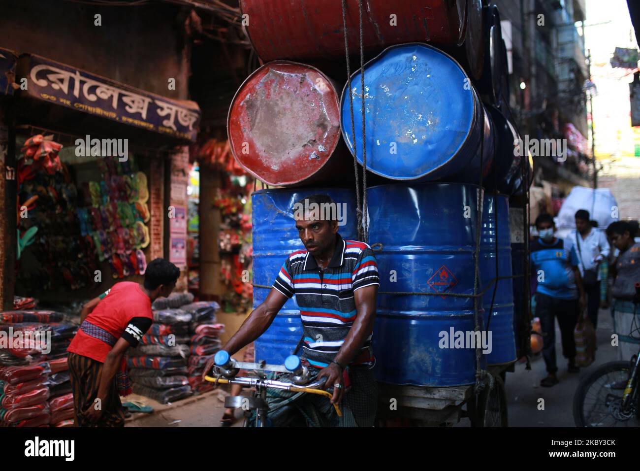 A van-puller makes his way in a tiny busy street at Chawk Bazar ...