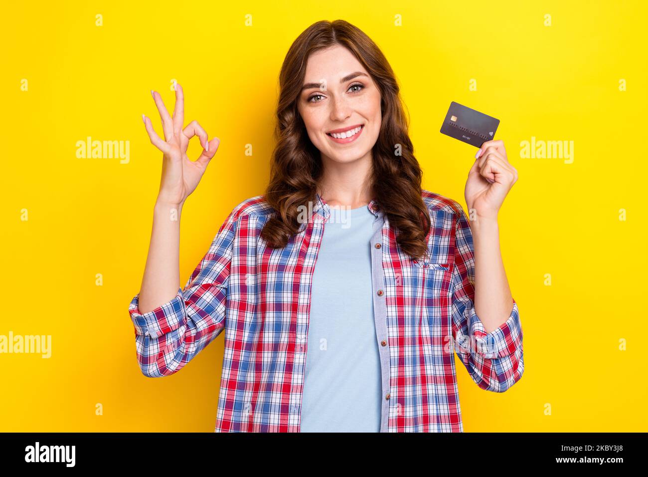 Photo of charming cute girl dressed checkered shirt rising debit card ...