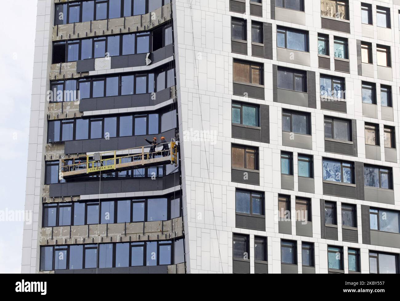 Workers talk at a construction site of new build an apartment building ...