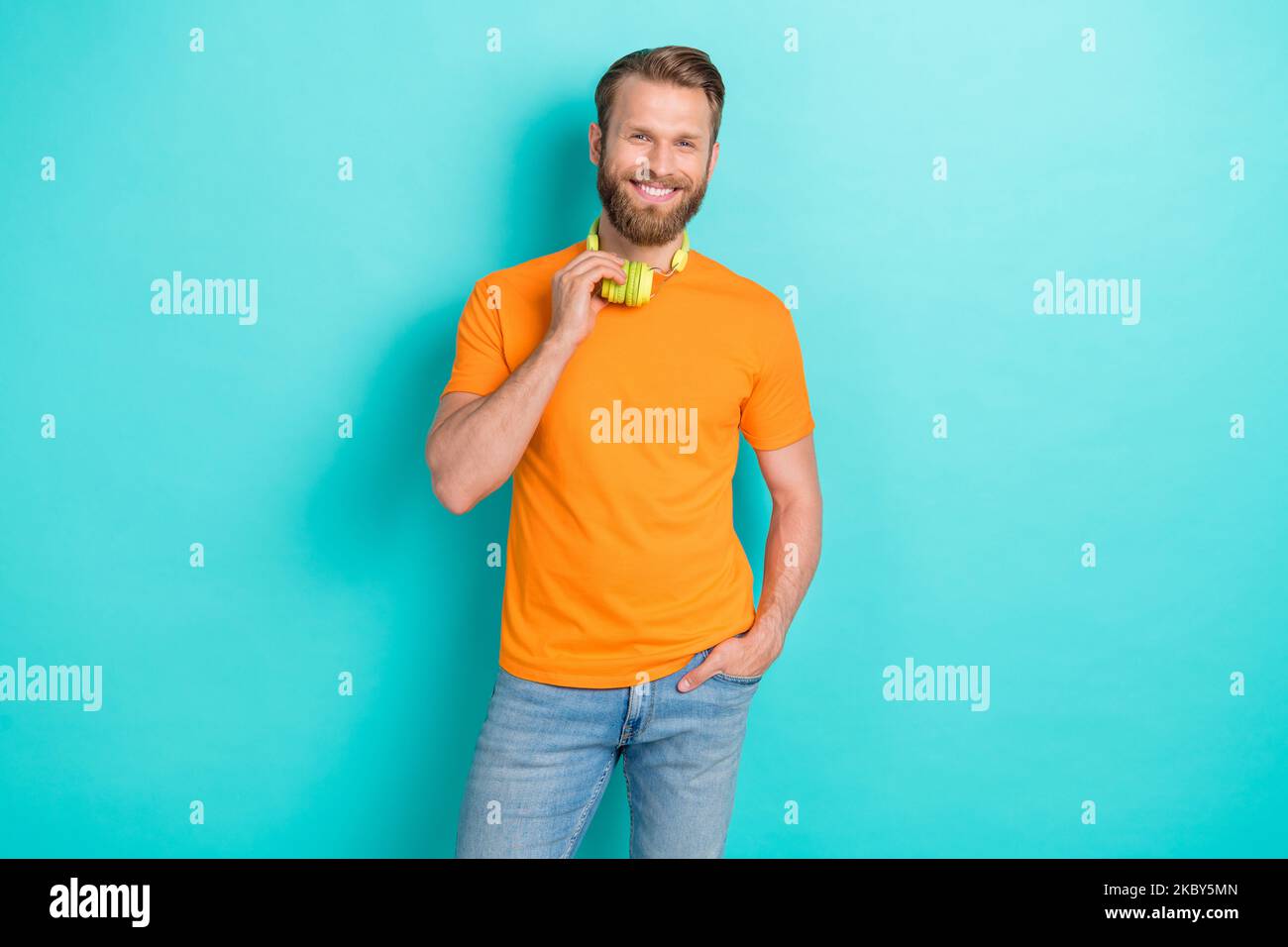 Photo of good beard guy listen music wear orange t-shirt jeans isolated ...