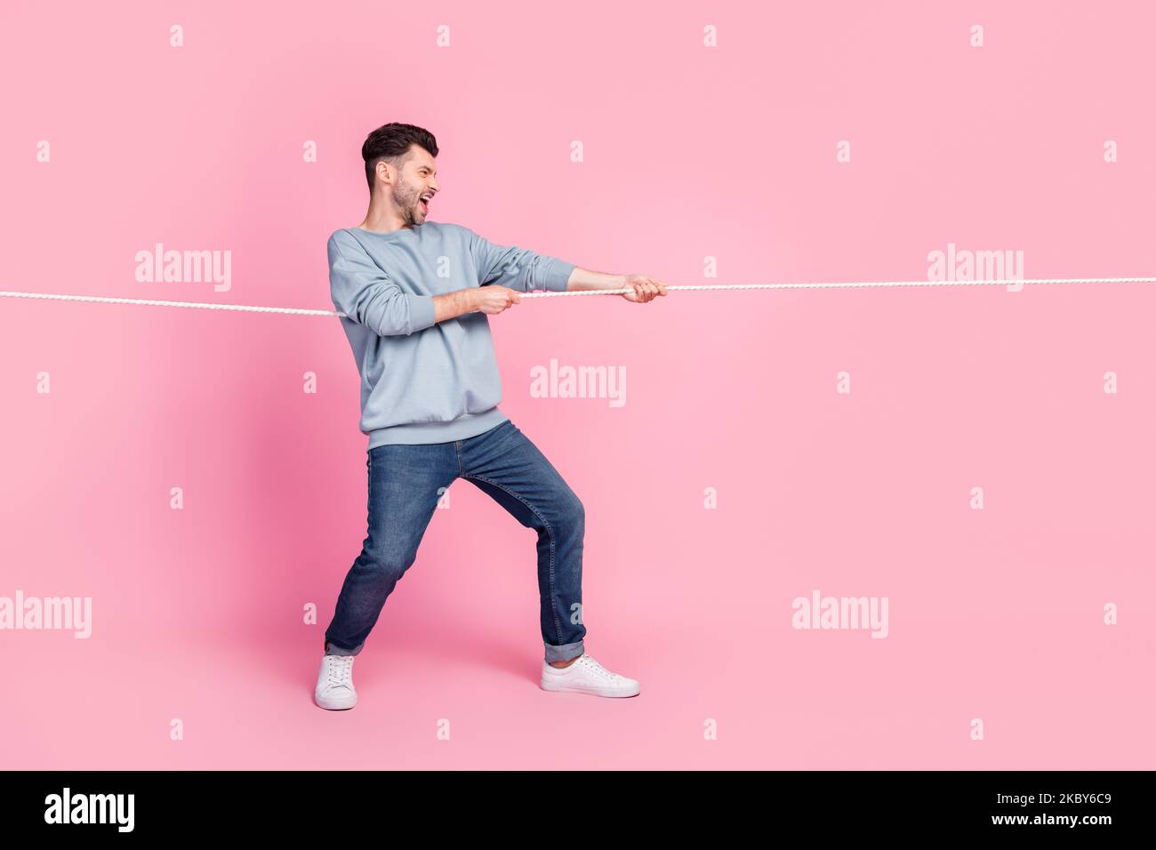 Profile side full body photo of determined guy pulling string winning ...