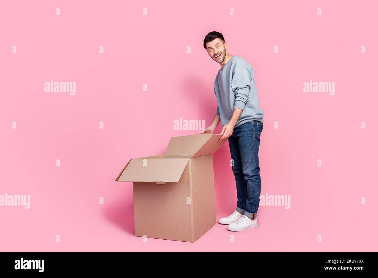Full size photo of handsome young guy excited opening big parcel empty ...