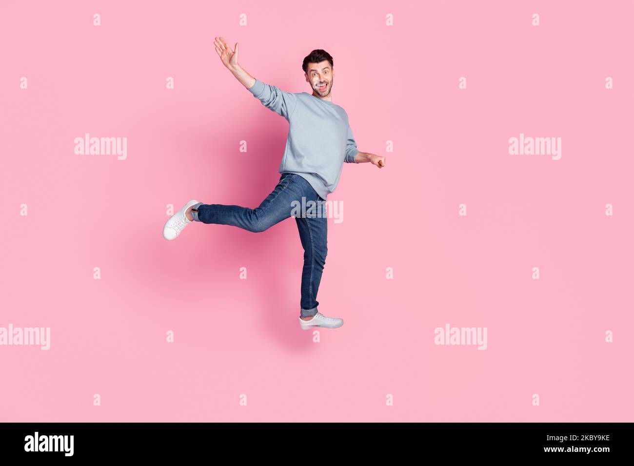 Full size photo of handsome young man jumping carry invisible shopping ...