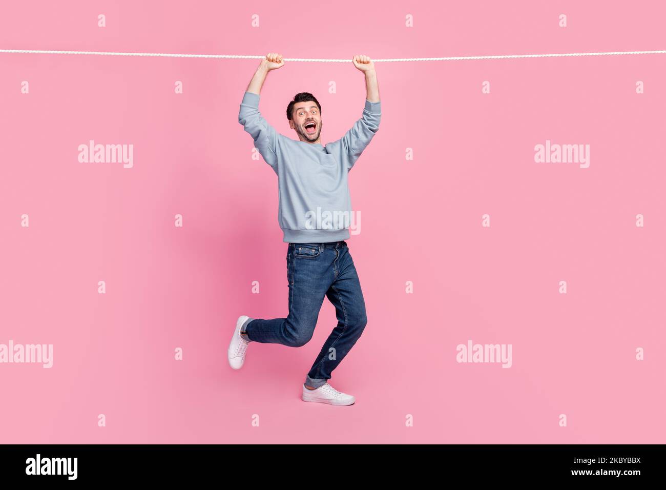 Full length photo of carefree guy hang on string playing game isolated ...