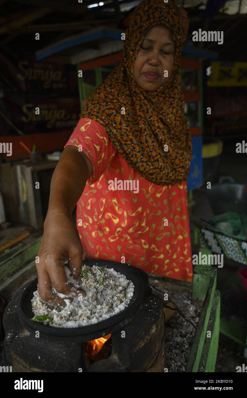 A mother cooks a typical Tolitoli ambal in Baru Village, Tolitoli ...