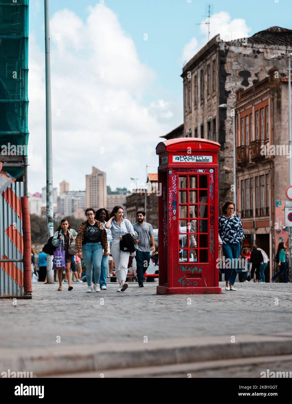 A red telephone cell with people walking by in Porto, Portugal Stock ...