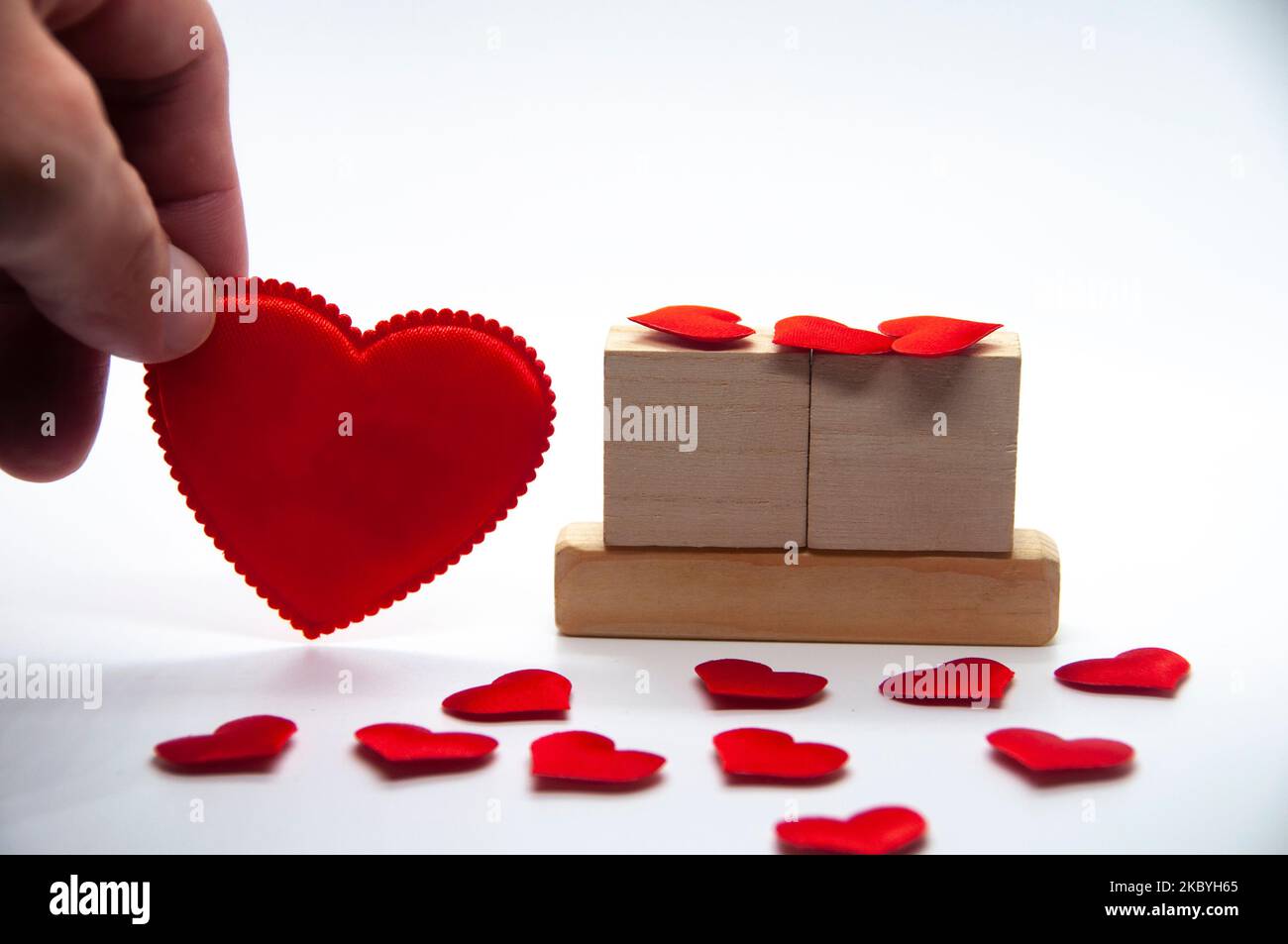 Hand holding blank heart shape with empty wooden block on with ...