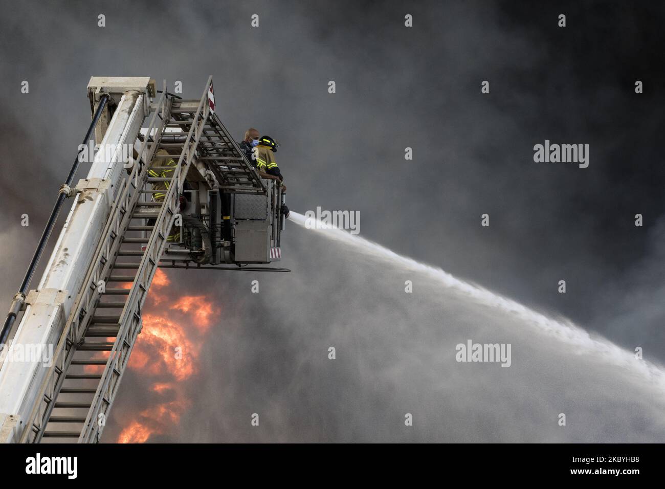Firefighters try to douse flames billowing from a huge fire that broke ...
