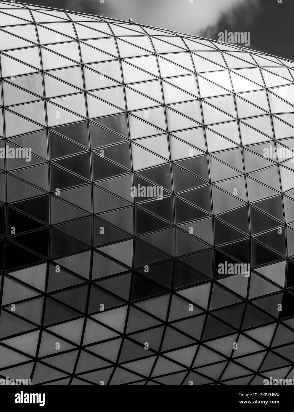 A grayscale shot of glass windows with triangular patterns Stock Photo ...