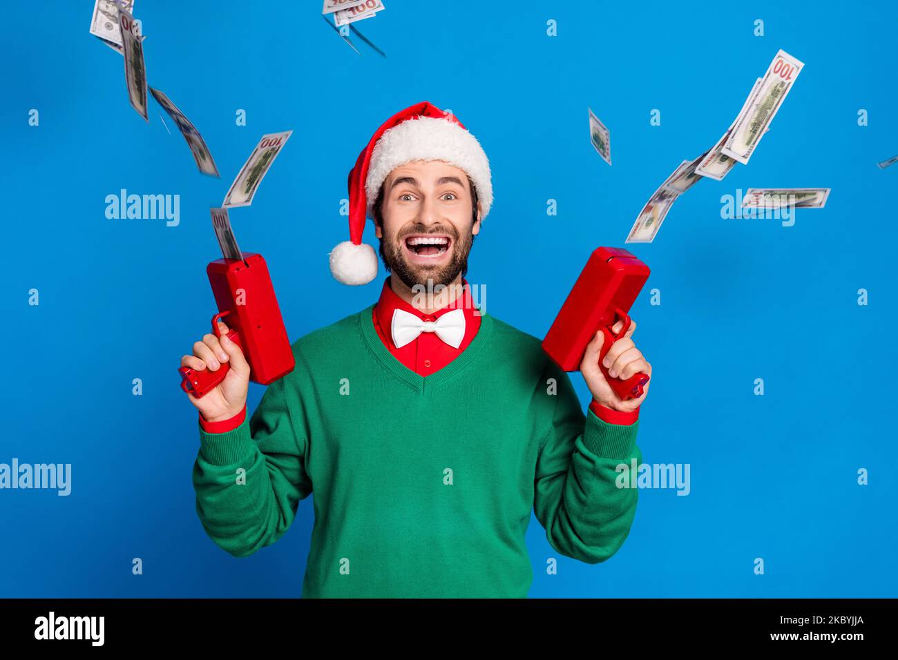 Photo of successful excited handsome guy hands hold money gun flying ...
