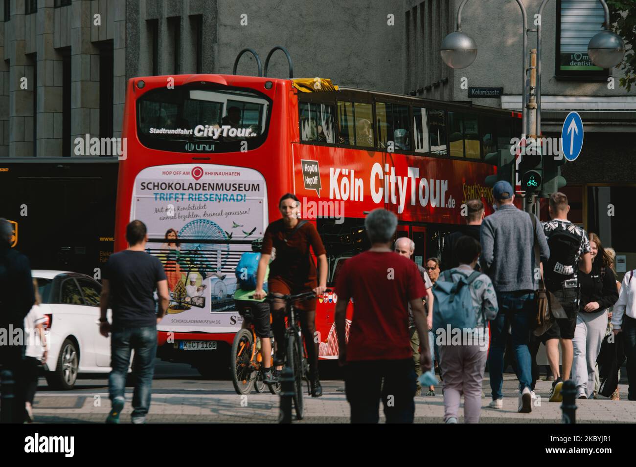 A tourist bus is seen as people cross the street in the city center of ...