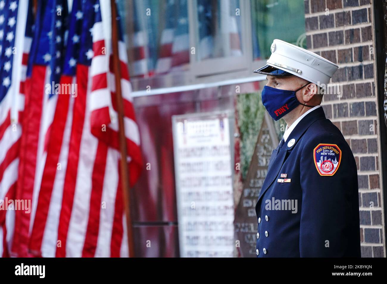 A FDNY personnel wearing a mask stands guard at 9/11 FIREFIGHTERS ...