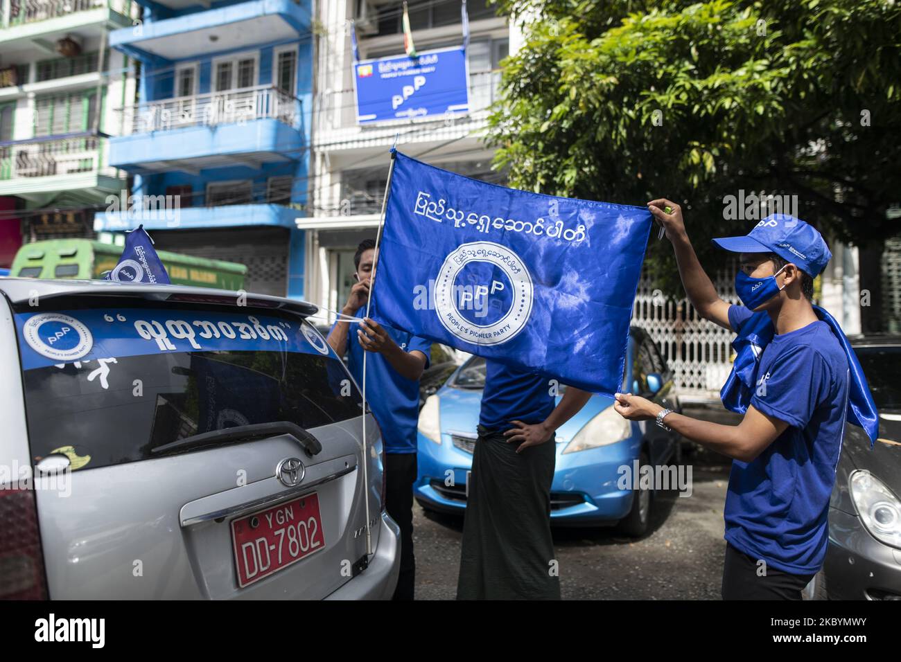 A volunteer tie a flag of the People's Pioneer Party (PPP) on the back ...