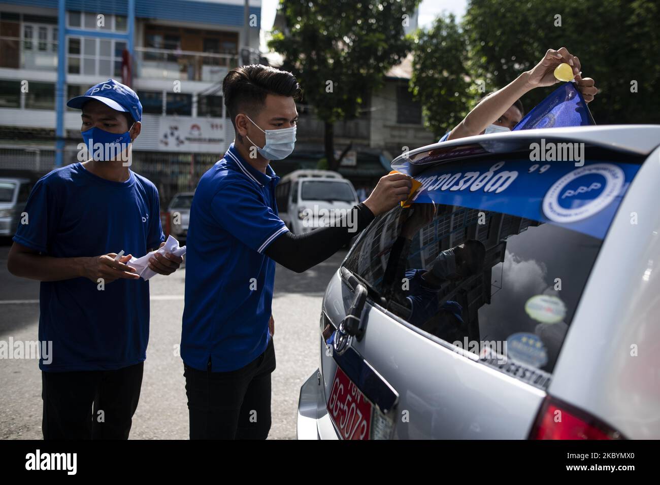 A volunteer puts a sticker of the slogan of the People's Pioneer Party ...