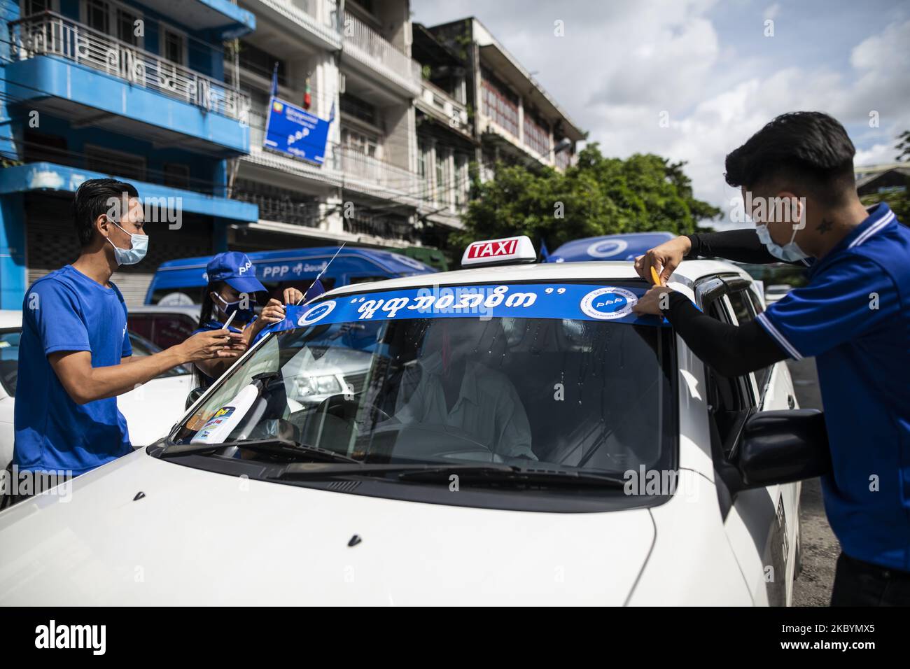 A volunteer puts a sticker of the slogan of the People's Pioneer Party ...