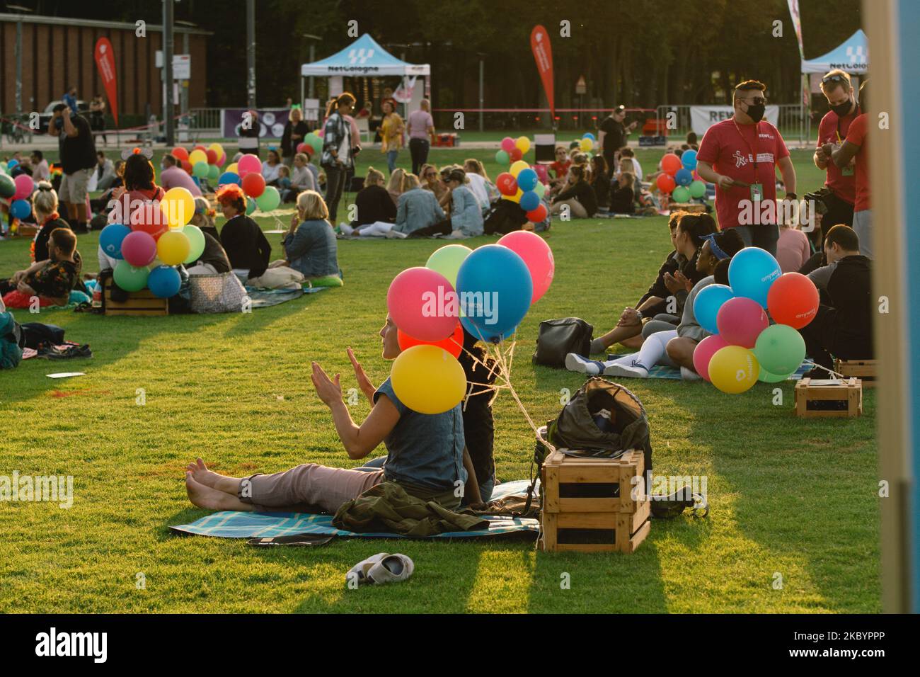 people sit apart from each other as groups during the outdoor concert ...