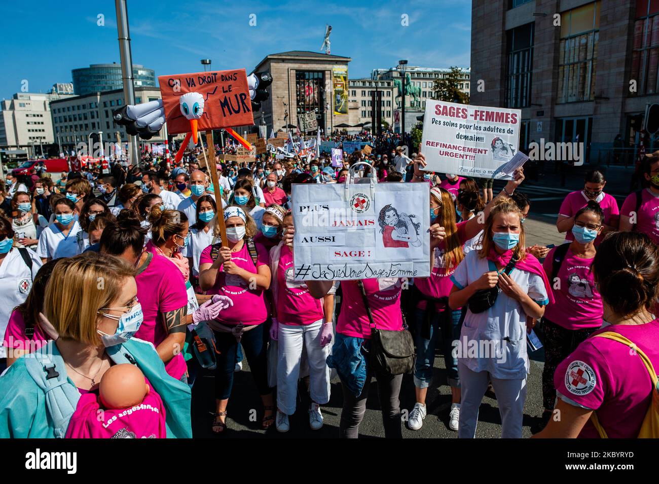 Hospital workers are holding placards for a better health care system ...