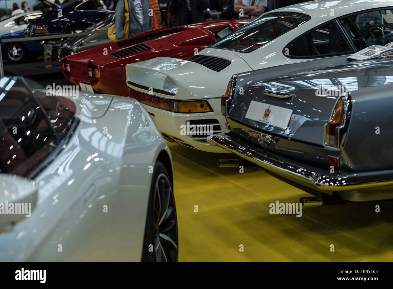 A white Aston Martin, gray Maserati, white Porsche 959, and red ...