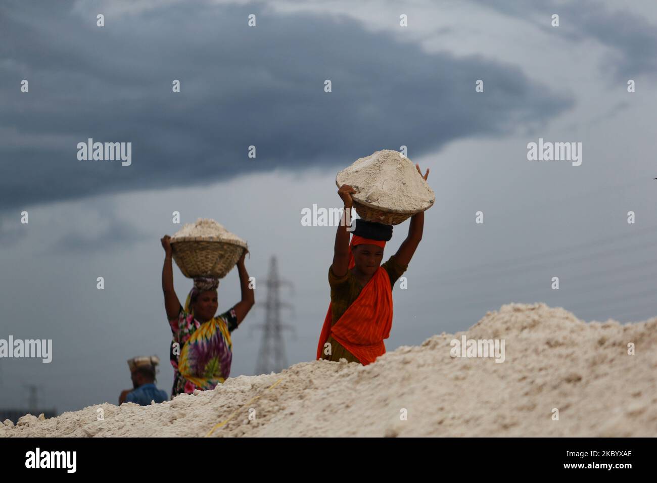 Labors carry sand as they unload from a ship in Dhaka, Bangladesh on ...