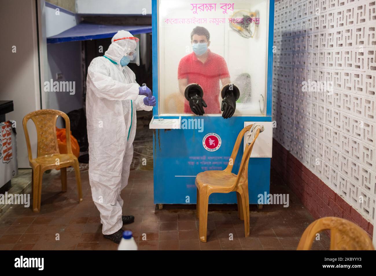 In a COVID 19 test sample collection booth while medical employees are ...