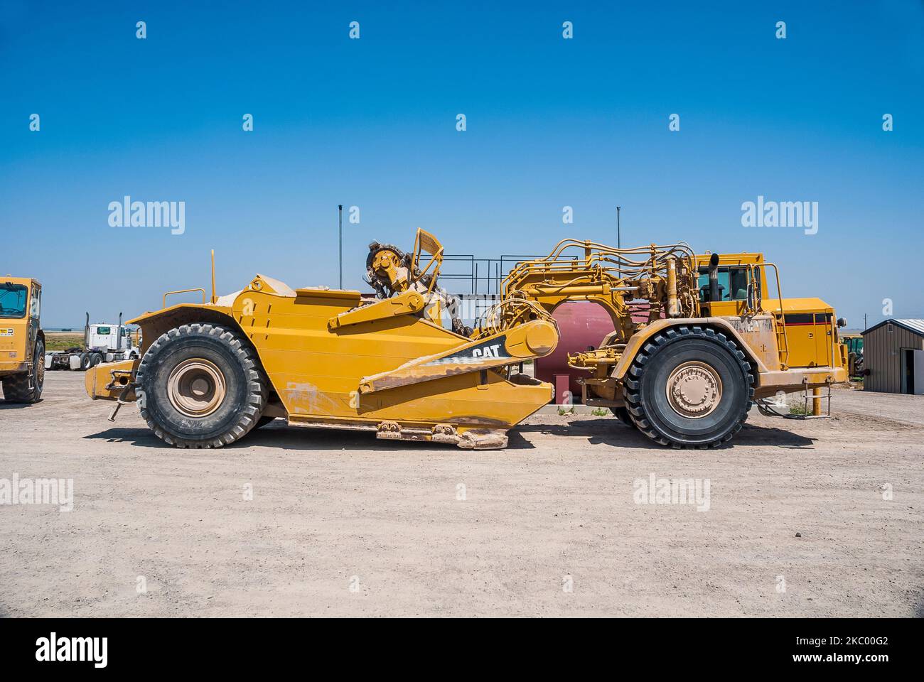 A large segmented Caterpillar heavy equipment tractor is parked in an ...