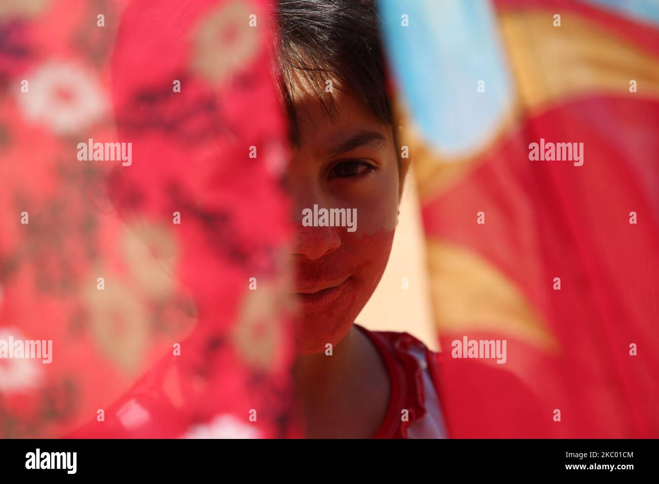 The young artist, Osama Alali, 13, draws masks on the faces of children ...