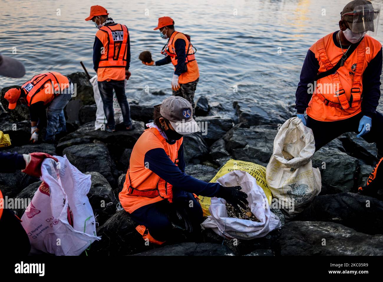 Workers and volunteers clean a portion of Manila Bay in celebration of ...